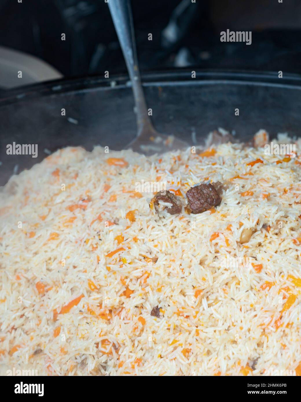 Cooking traditional Uzbek pilaf with rice and meat Stock Photo - Alamy