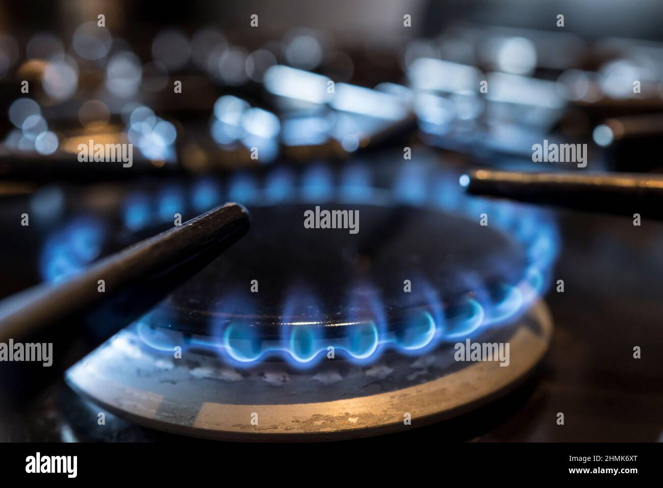 Close up of flaming gas rings lit on the hob of a domestic gas cooker ...
