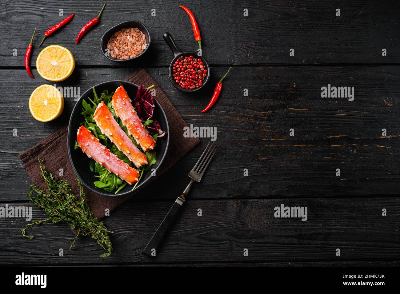 Crab leg meat in a sheel set, on black wooden table background, top ...