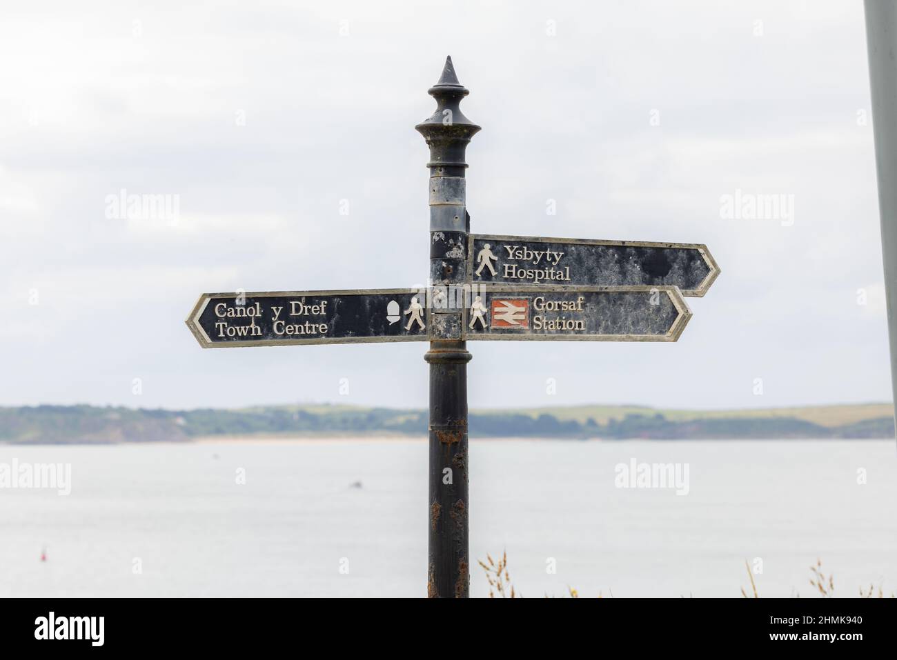 Sign directions on a metallic pipe in the background of the seascape ...
