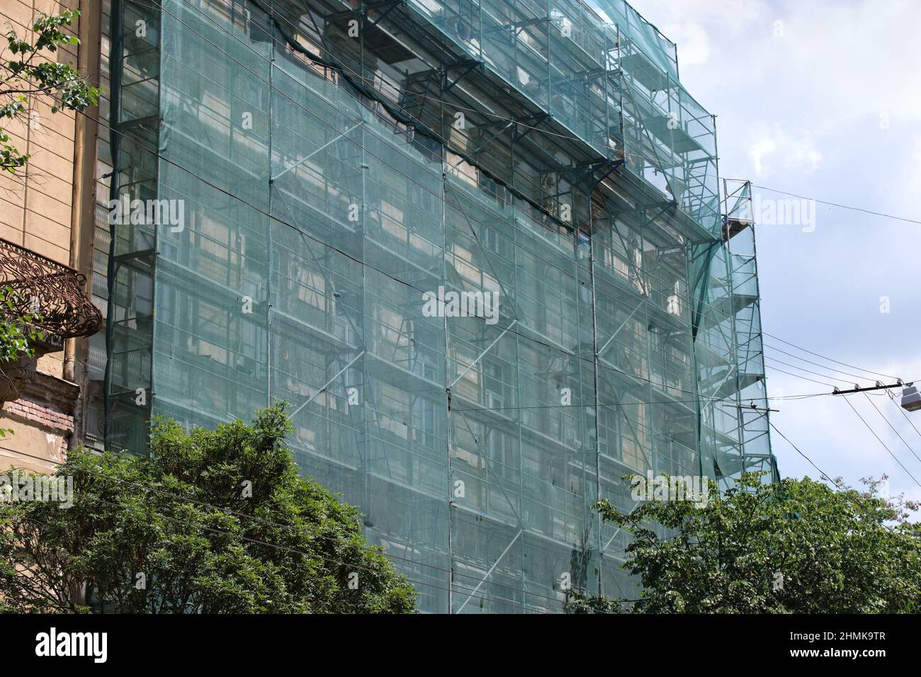 Building facade under renovation works with construction scaffolding ...