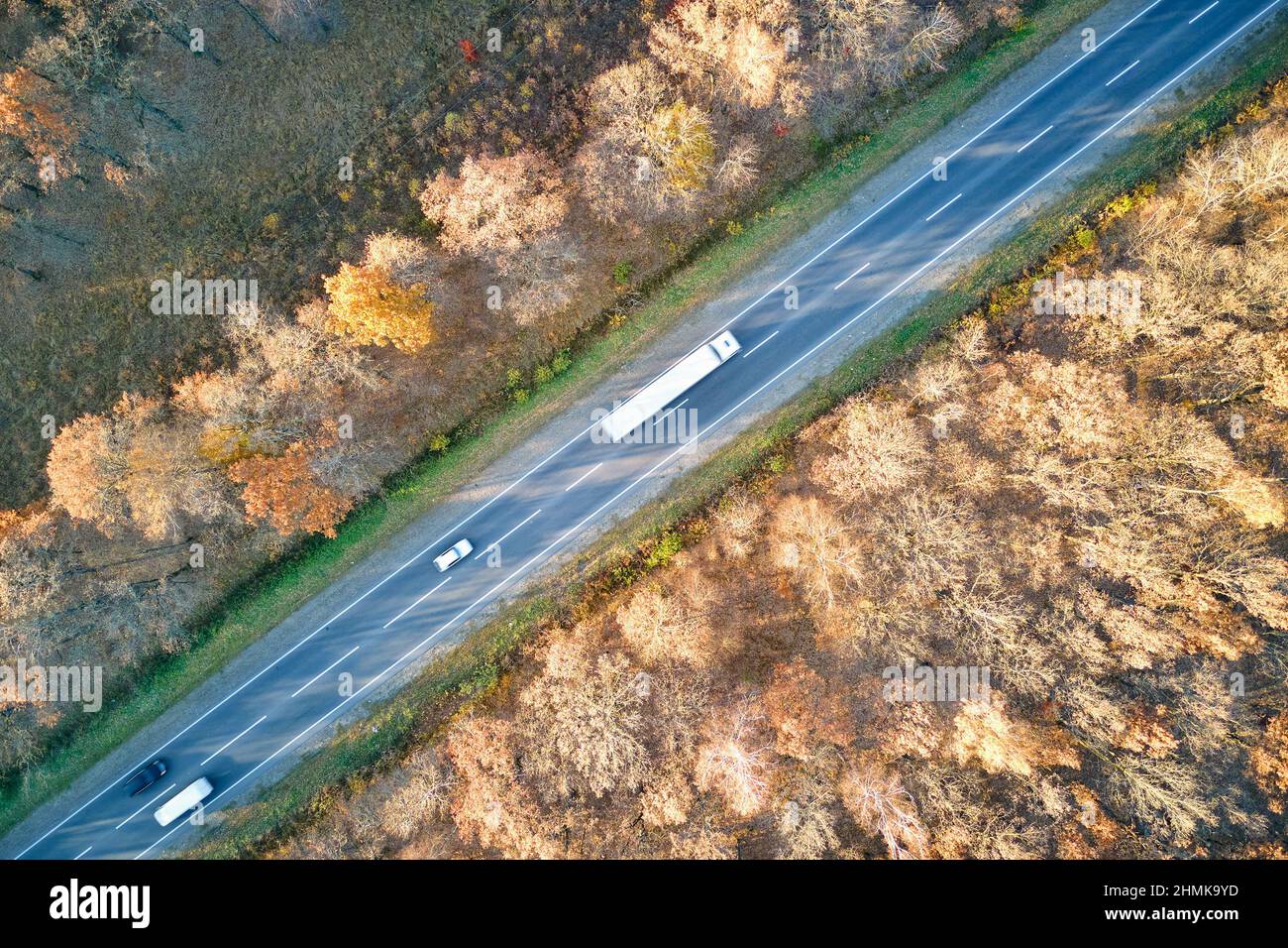 Aerial view of semi-truck with cargo trailer driving on highway hauling ...