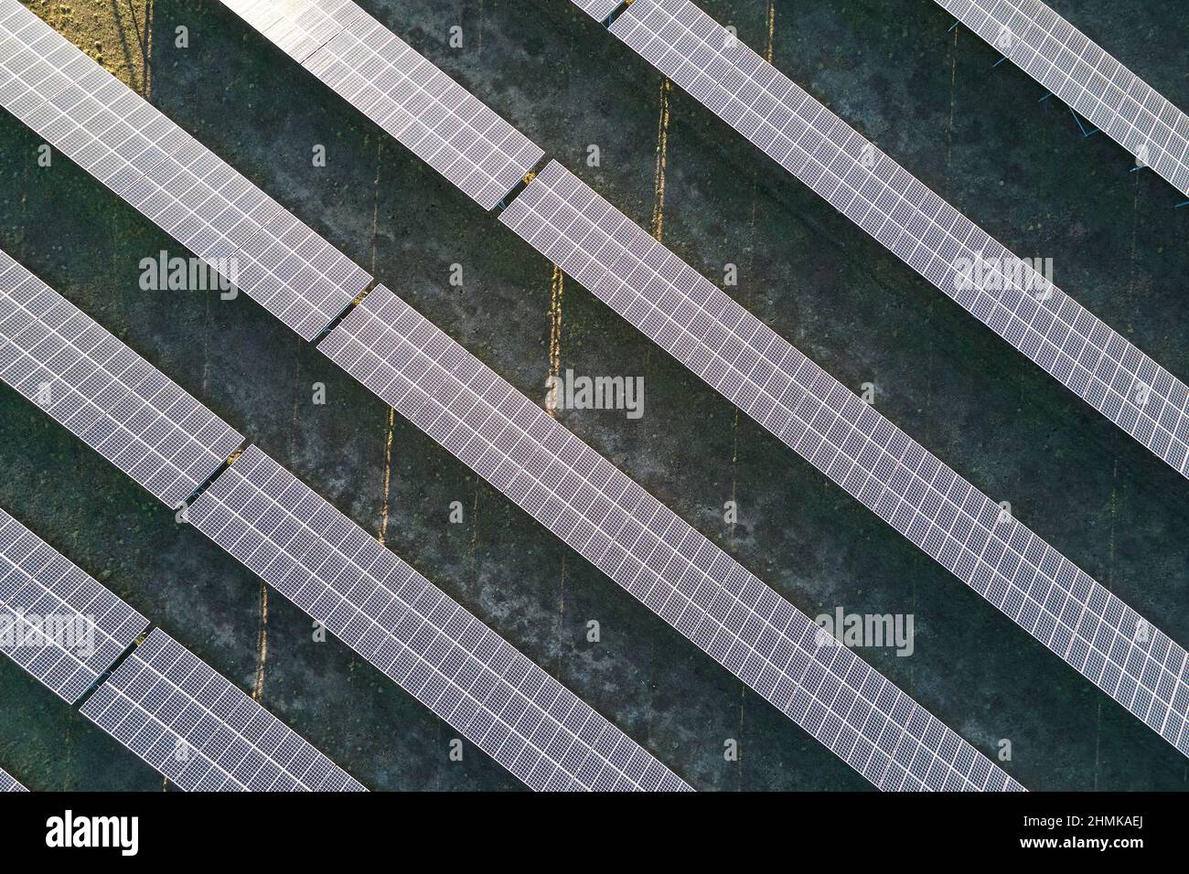 Aerial view of large sustainable electrical power plant with rows of solar photovoltaic panels ...