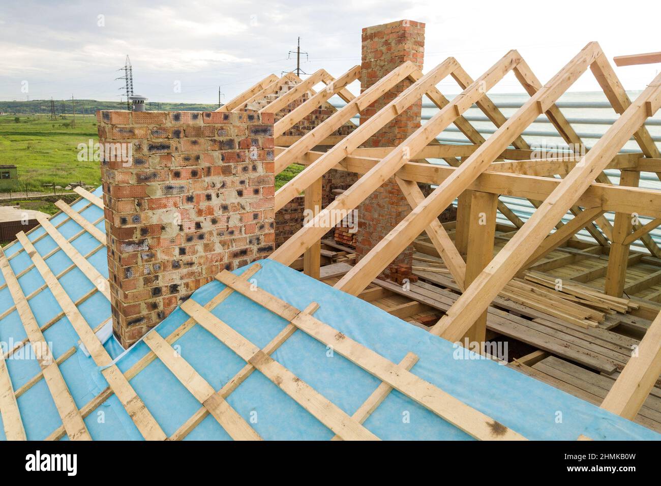 Aerial view of a brick house with wooden roof frame under construction ...
