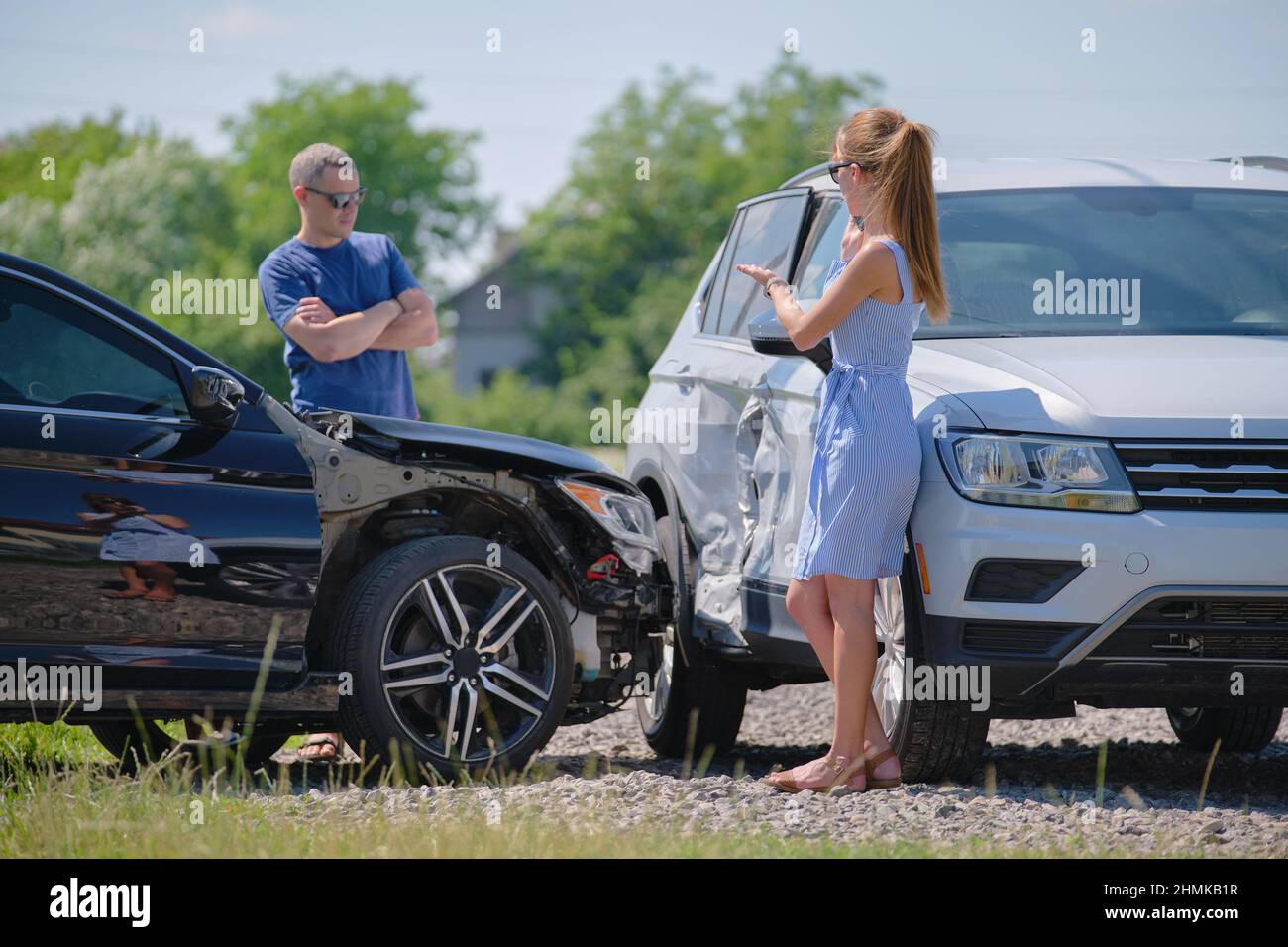 Angry woman and man drivers of heavily damaged vehicles arguing who is ...
