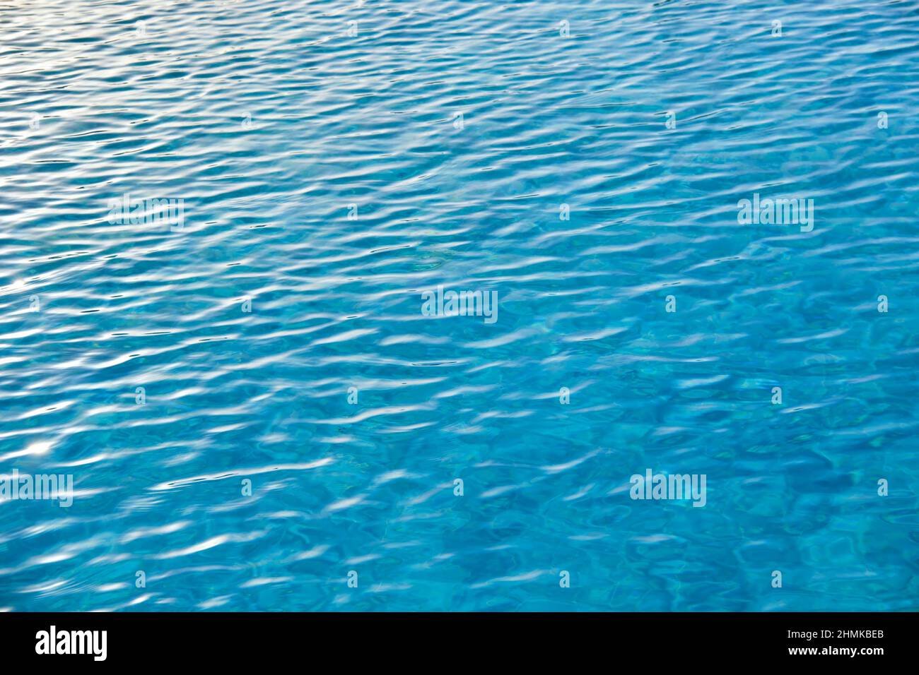 Closeup surface of blue clear water with small ripple waves in swimming ...