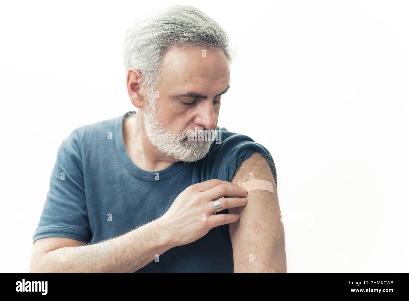 Middle-aged man showing the arm patch after the covid-19 vaccination ...