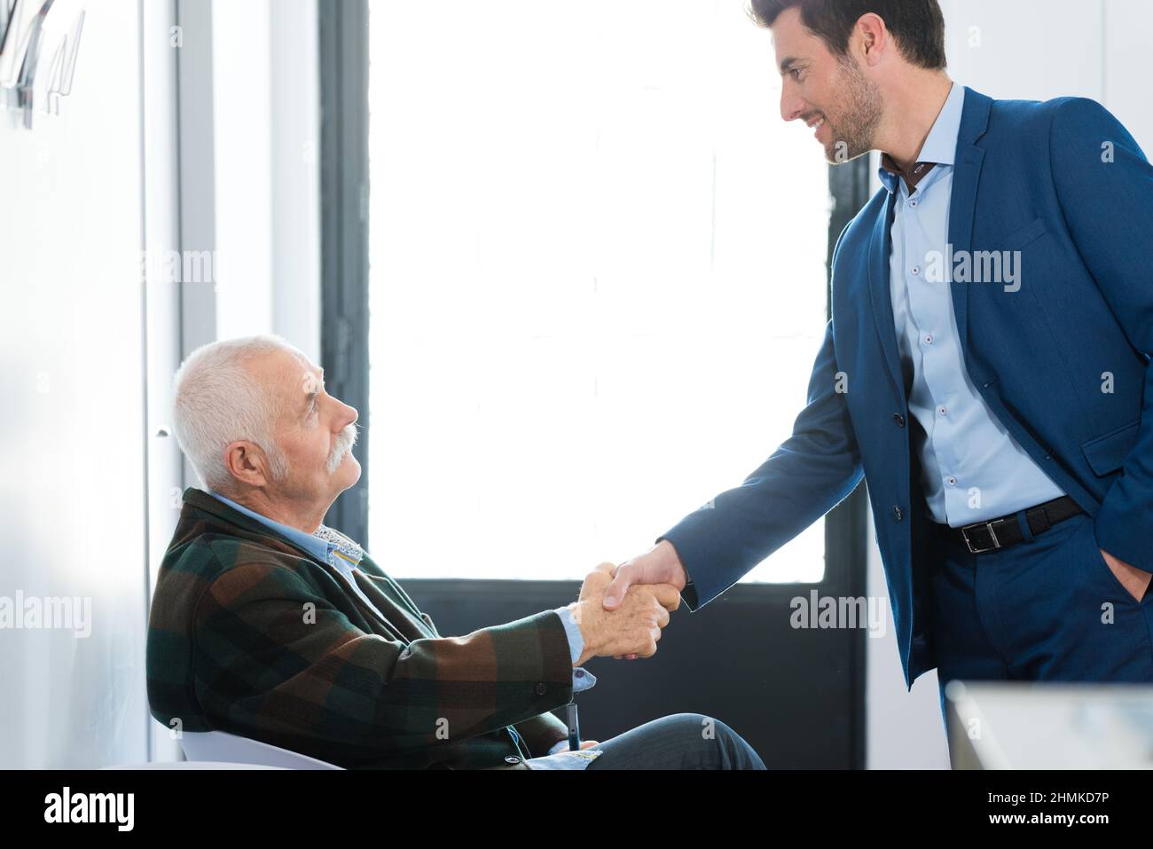 businessman greeting senior client in waiting room Stock Photo - Alamy