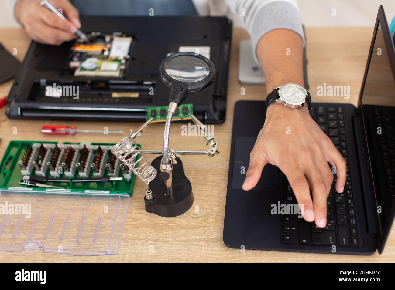 a repairman disassembling laptop motherboard Stock Photo - Alamy
