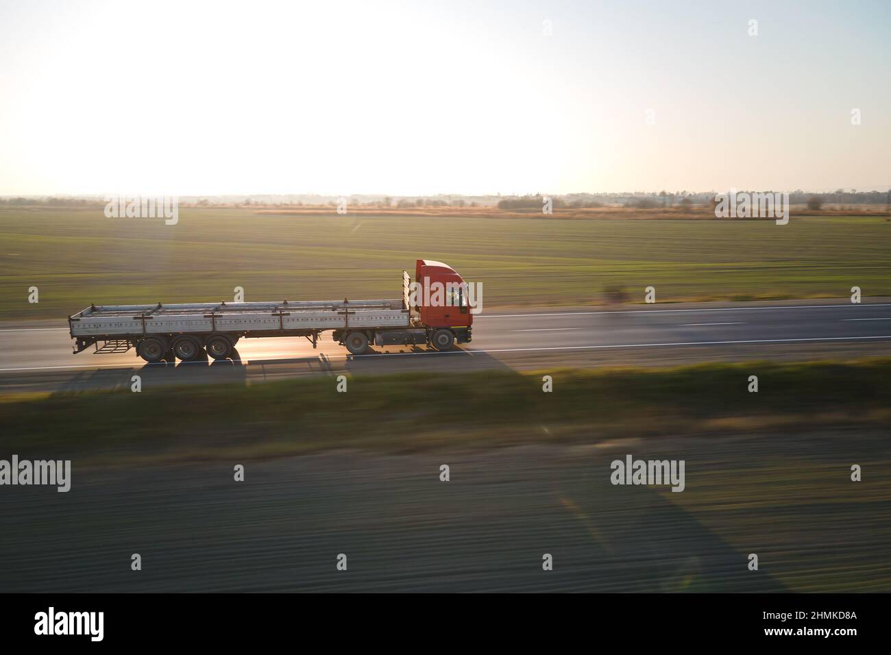Aerial view of blurred fast moving semi-truck with cargo trailer ...