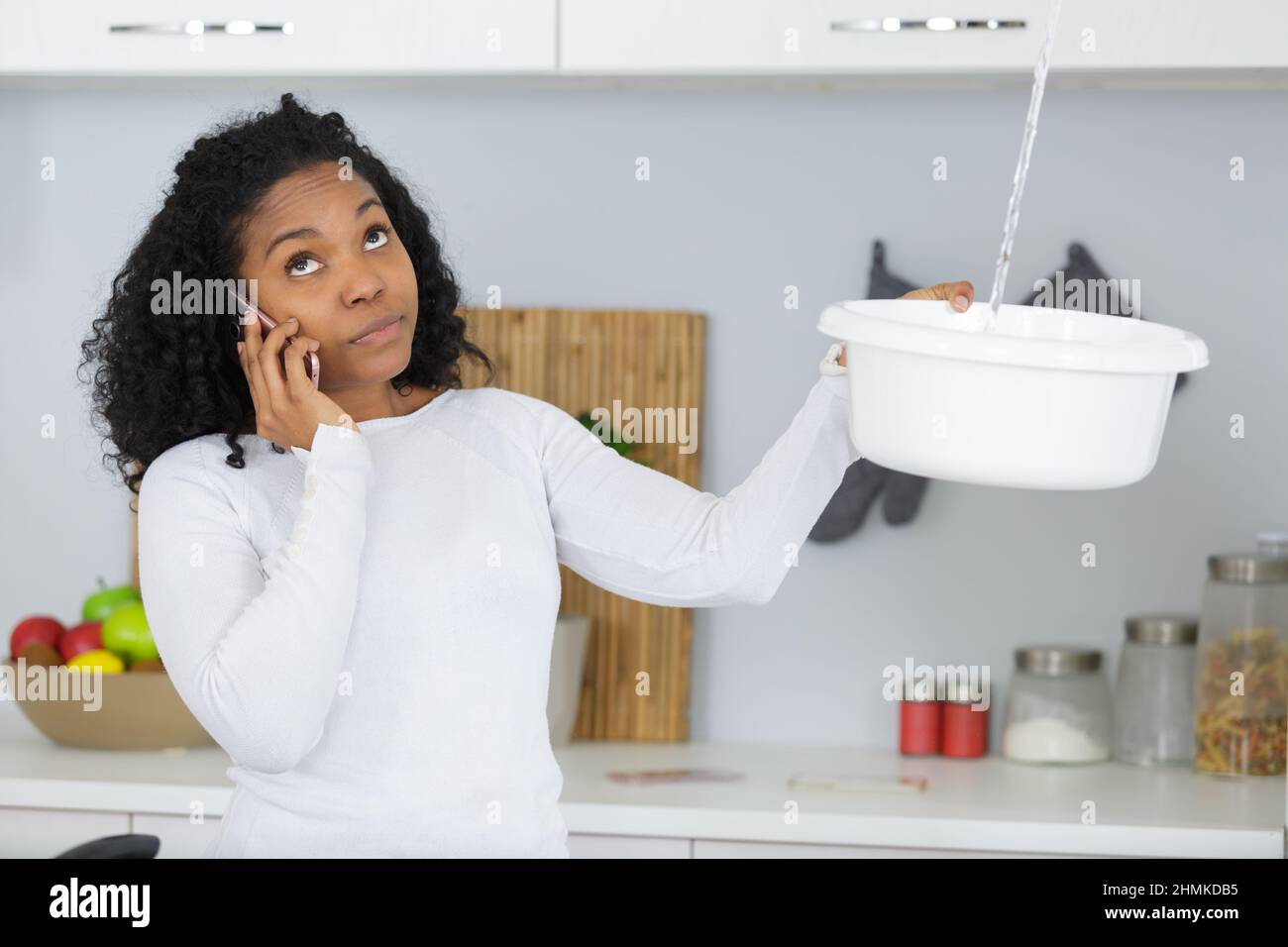 stressed woman calling plumber to fix water leaking from ceiling Stock ...