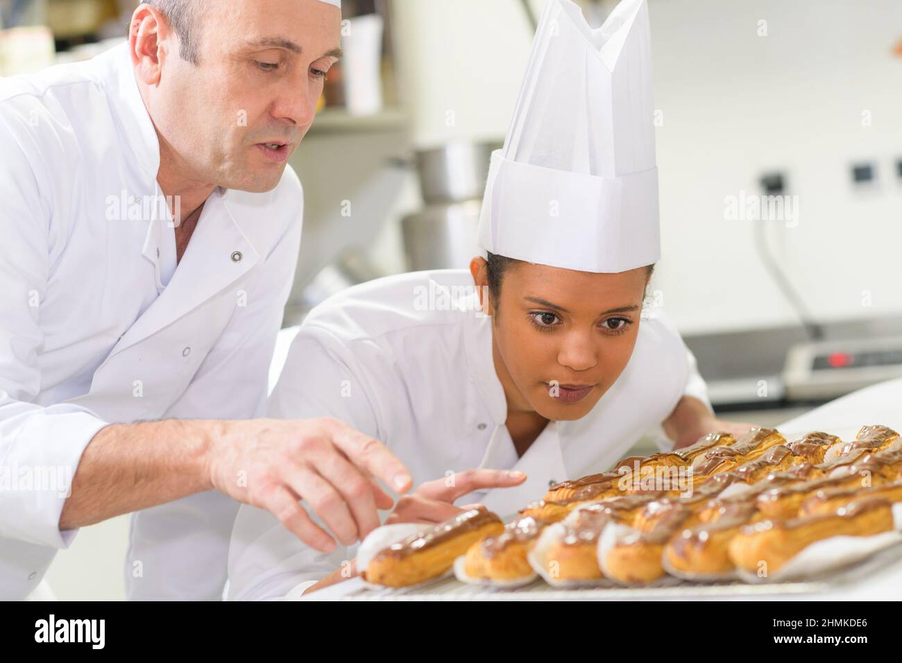 chef teaching female trainee to make eclairs Stock Photo - Alamy