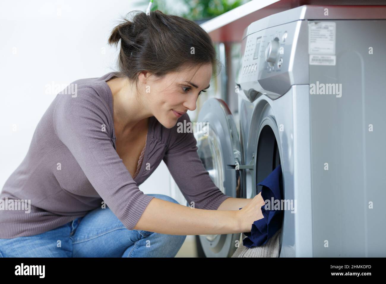 pretty woman loading the washing machine Stock Photo - Alamy