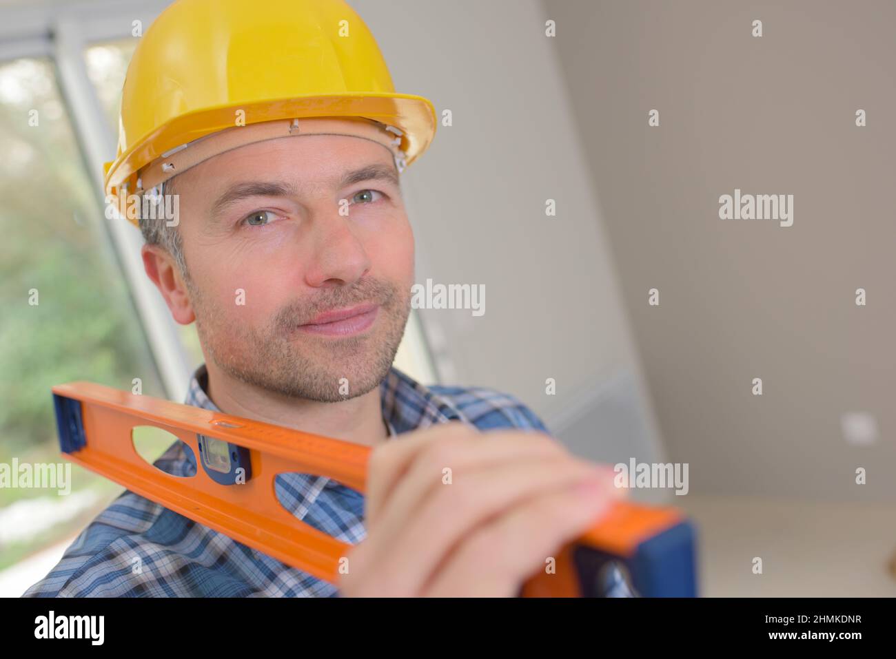 happy builder posing with spirit level at construction site Stock Photo ...