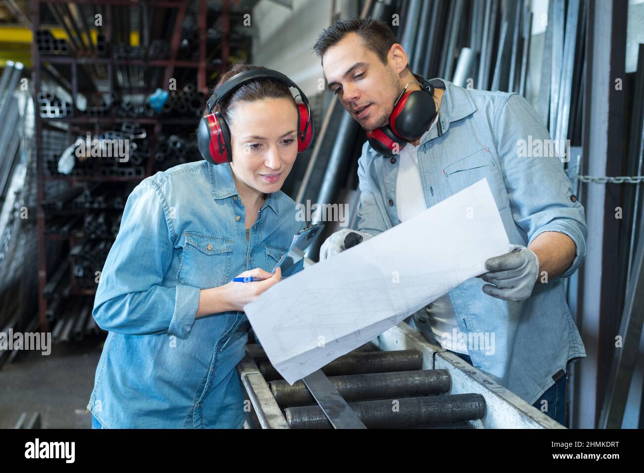 male inspector examining file by manual workers in industry Stock Photo ...