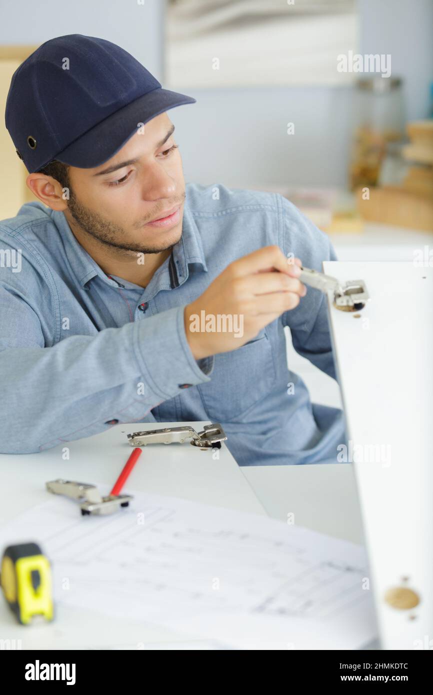 young man fitting wardrobe in kitchen cabinet Stock Photo - Alamy