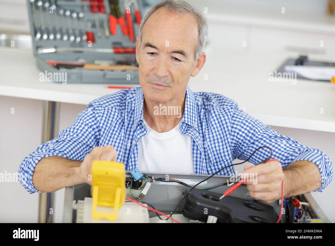 a mature man repairing a machine Stock Photo - Alamy