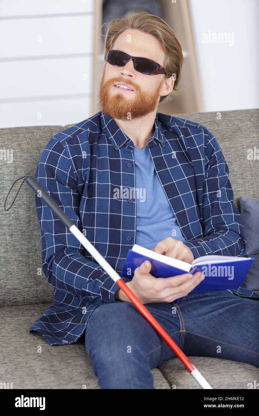 blind man reading braille book on the couch Stock Photo - Alamy