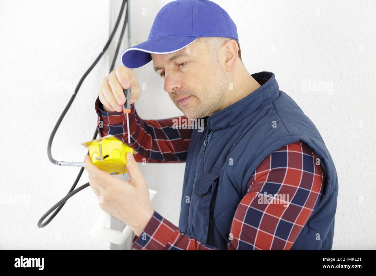 working contractor electrician fixing a cable Stock Photo - Alamy