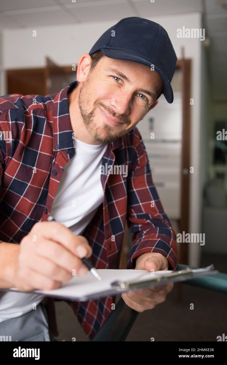 contractor writing on the clipboard Stock Photo - Alamy