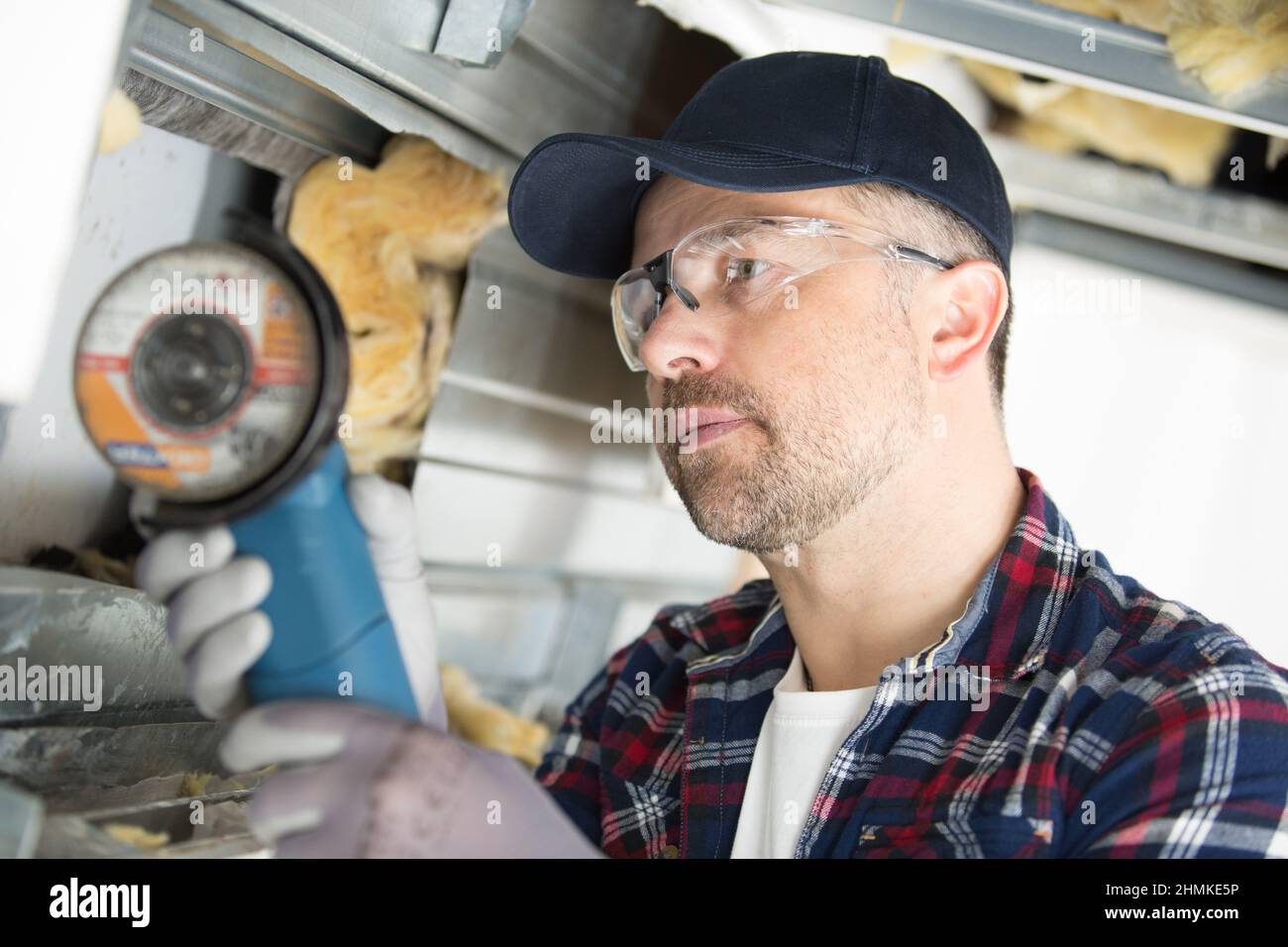 serious workman using angle grinder Stock Photo - Alamy