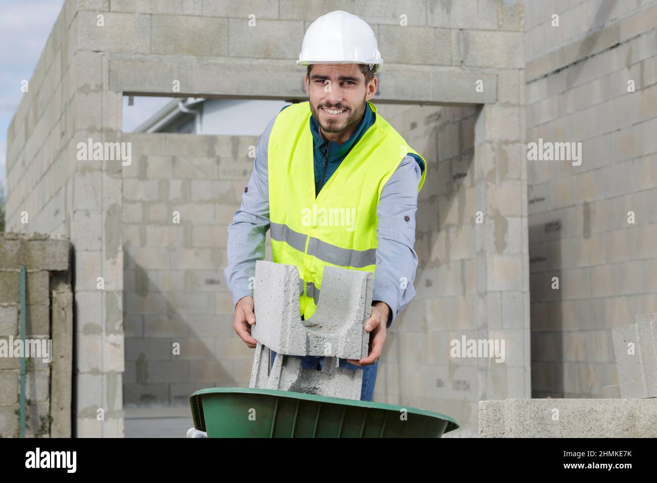 worker pushing a wheelbarrow full of bricks Stock Photo - Alamy