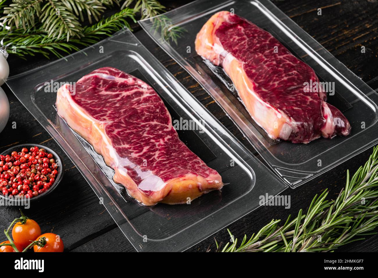 Fresh raw red meat vacuum sealed in plastic set, on black wooden table ...