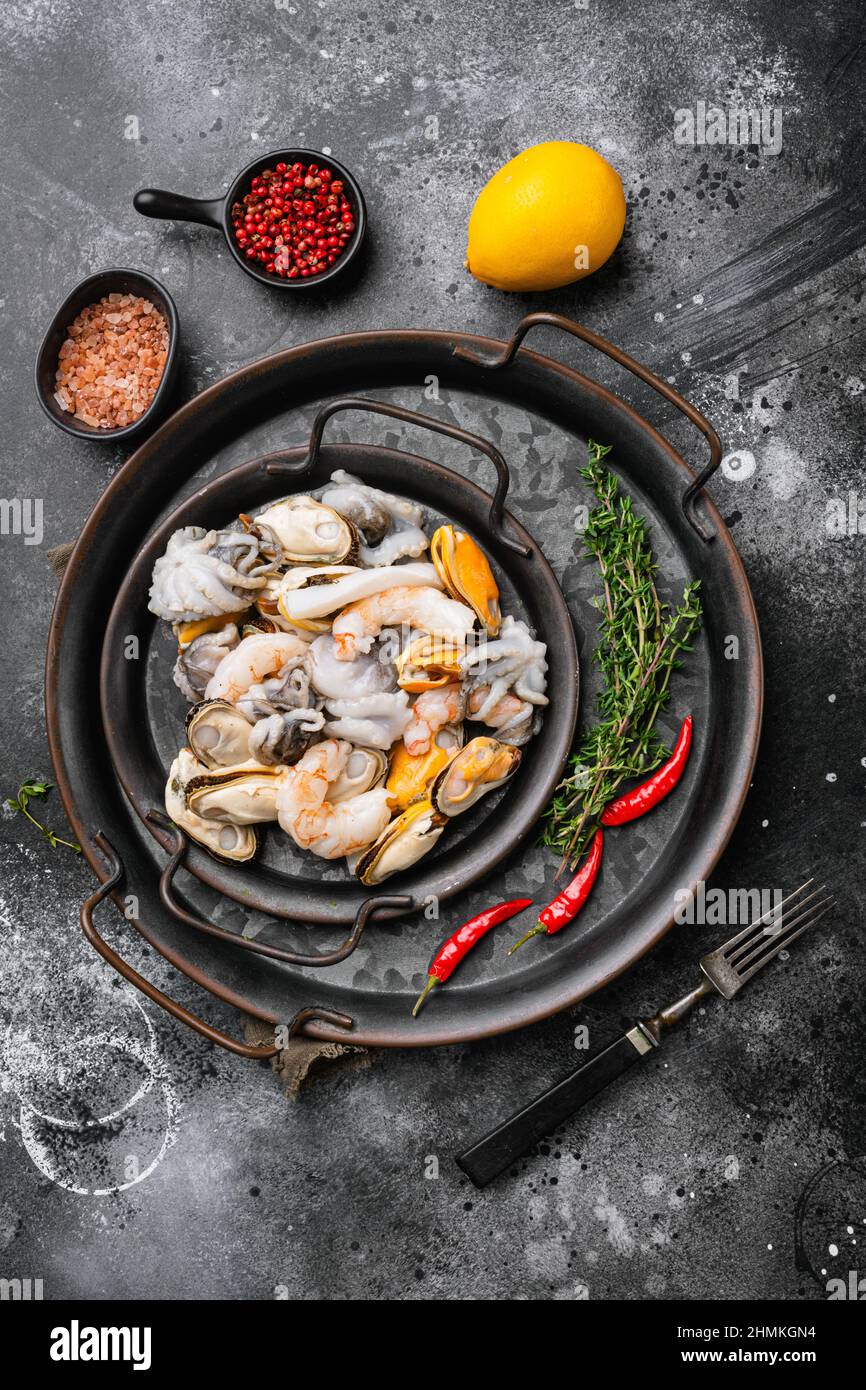 Raw seafood mussels, squid octopus set, on black dark stone table ...