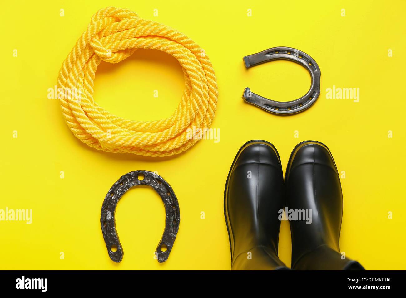 Boots with horseshoes and rope on color background Stock Photo - Alamy