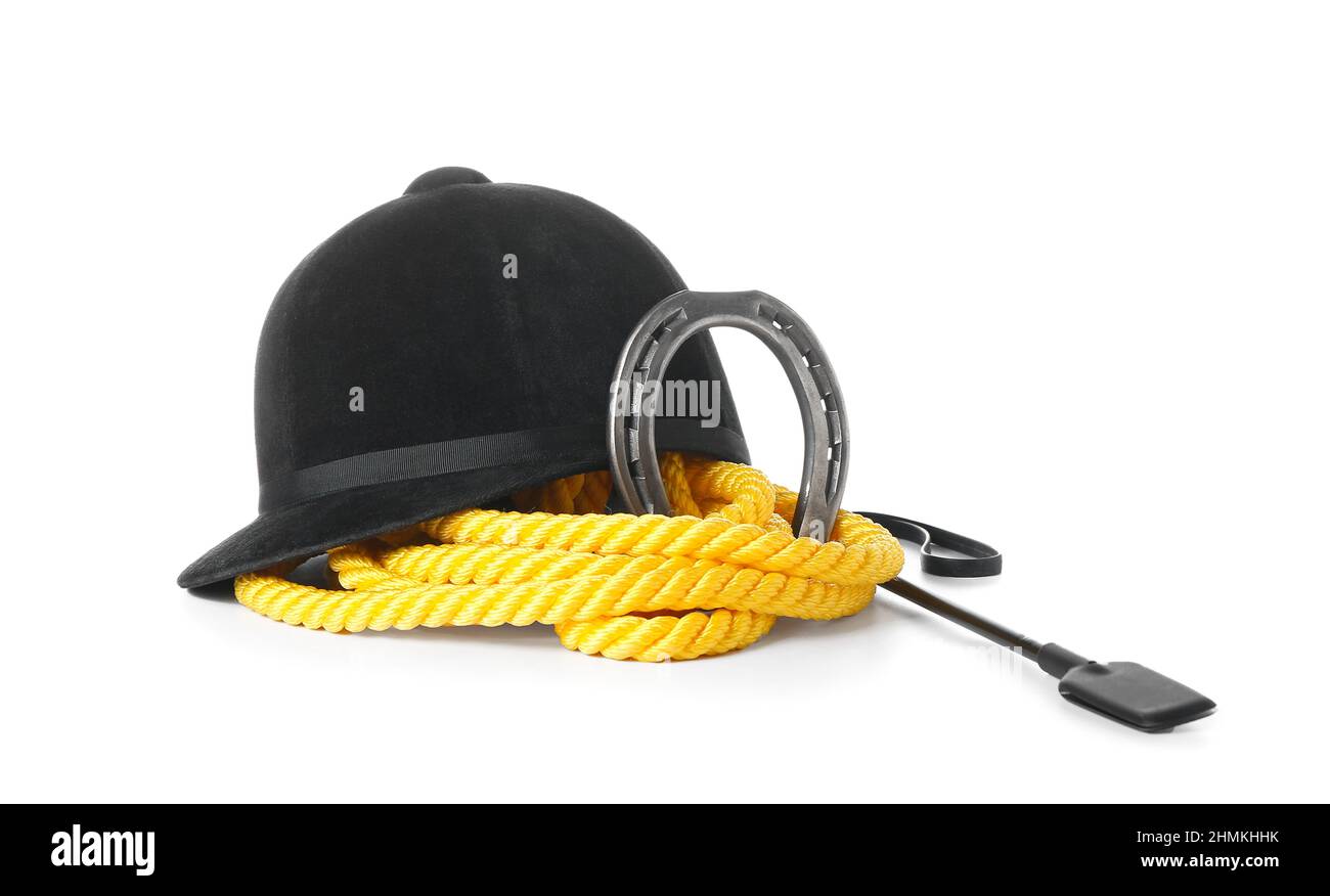 Horse riding helmet and crop with rope and horseshoe on white ...
