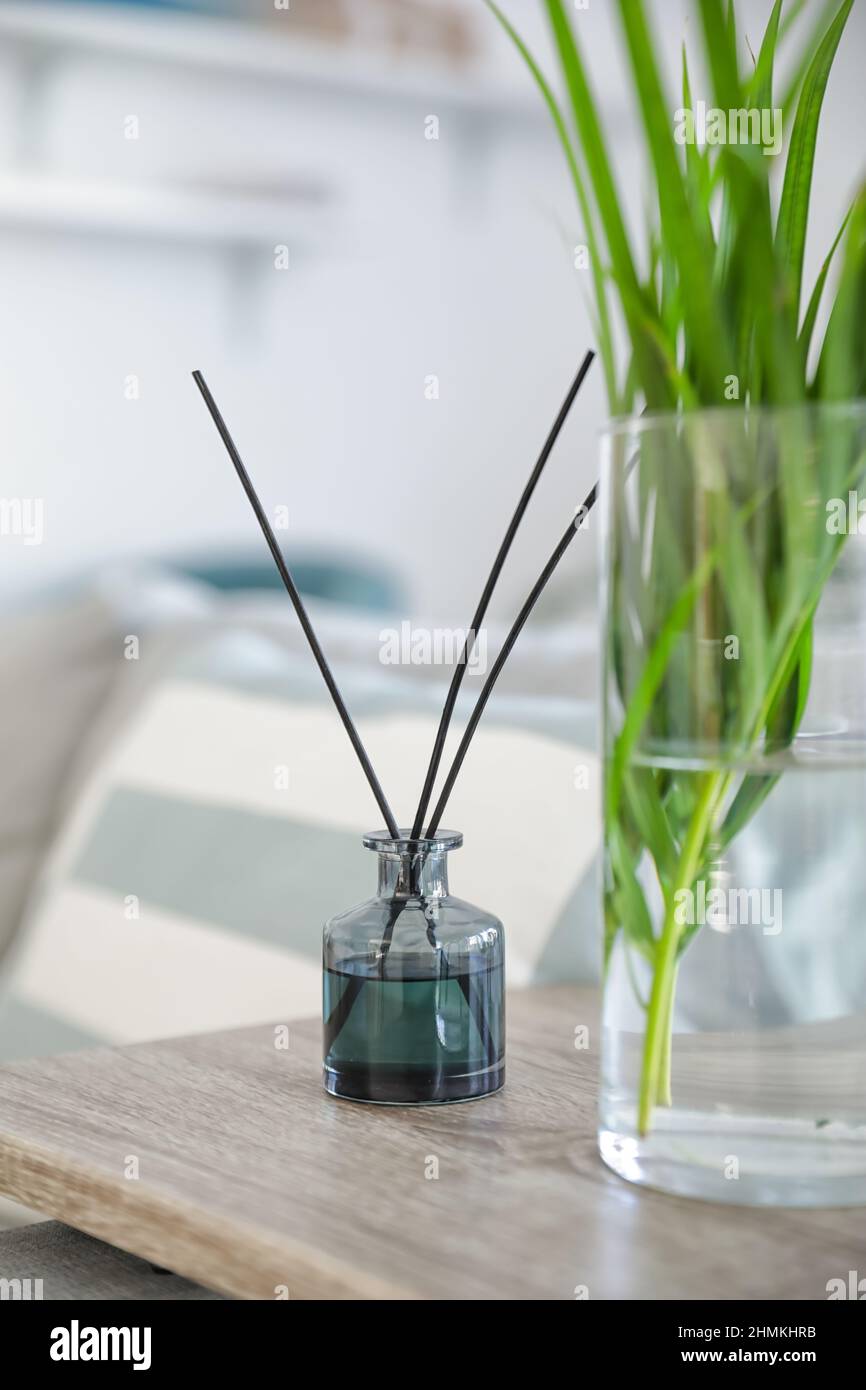 Aroma reed diffuser with vase on table in room Stock Photo - Alamy