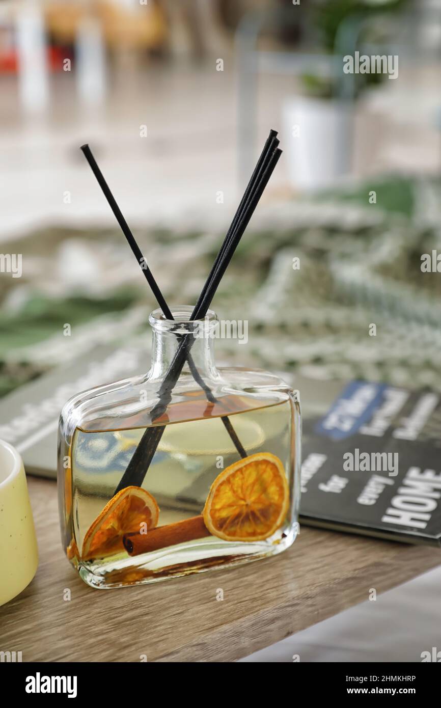 Aroma reed diffuser with magazine on table in room Stock Photo - Alamy