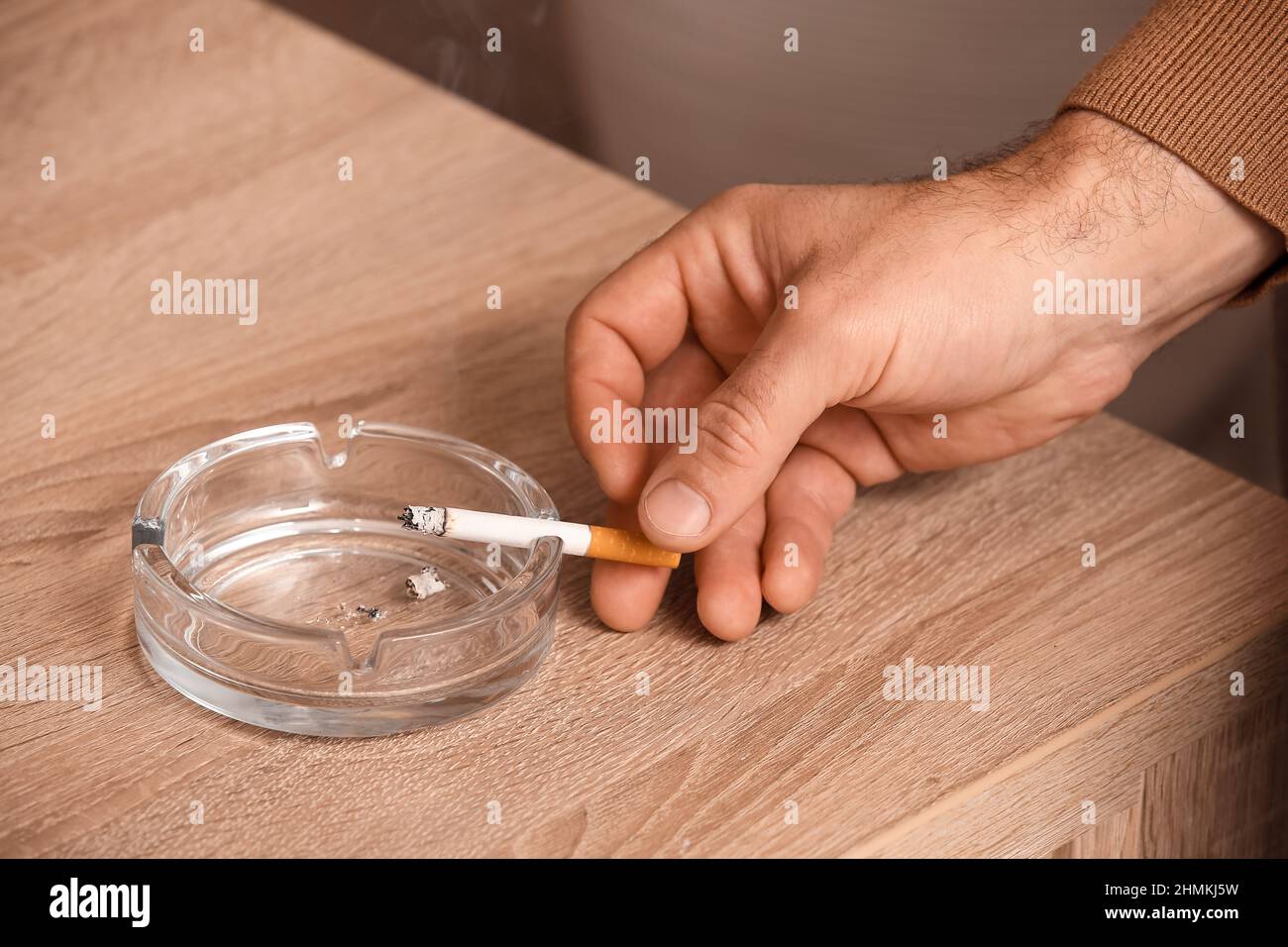 Smoking man using ash tray at home, closeup Stock Photo - Alamy