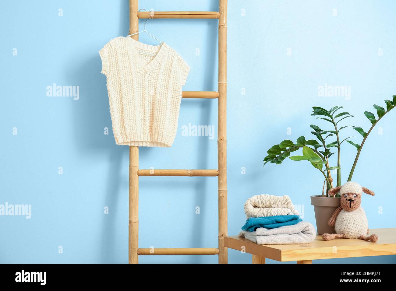 Different knitted sweaters in interior of room Stock Photo - Alamy
