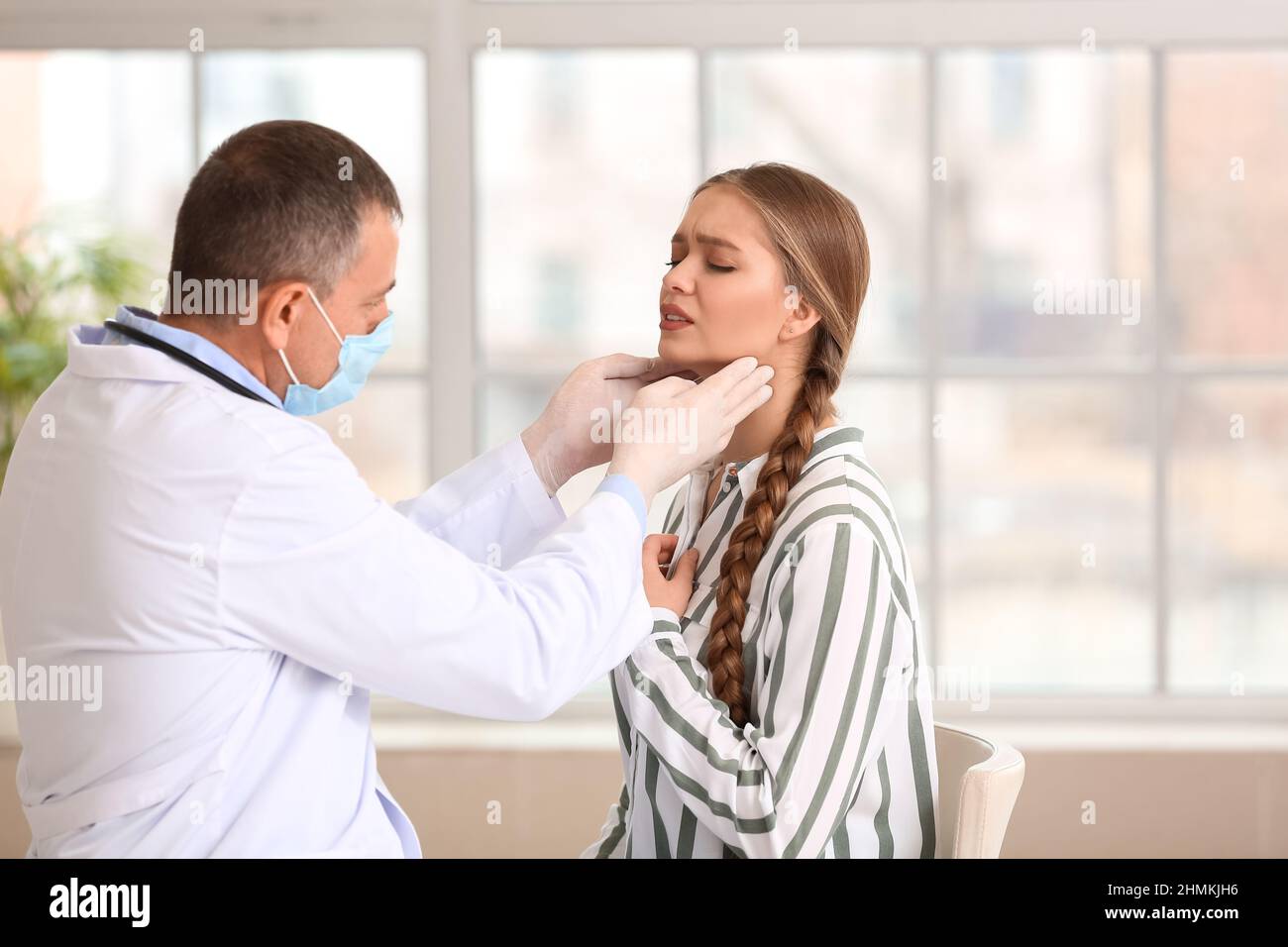 Doctor examining woman's neck in clinic Stock Photo - Alamy