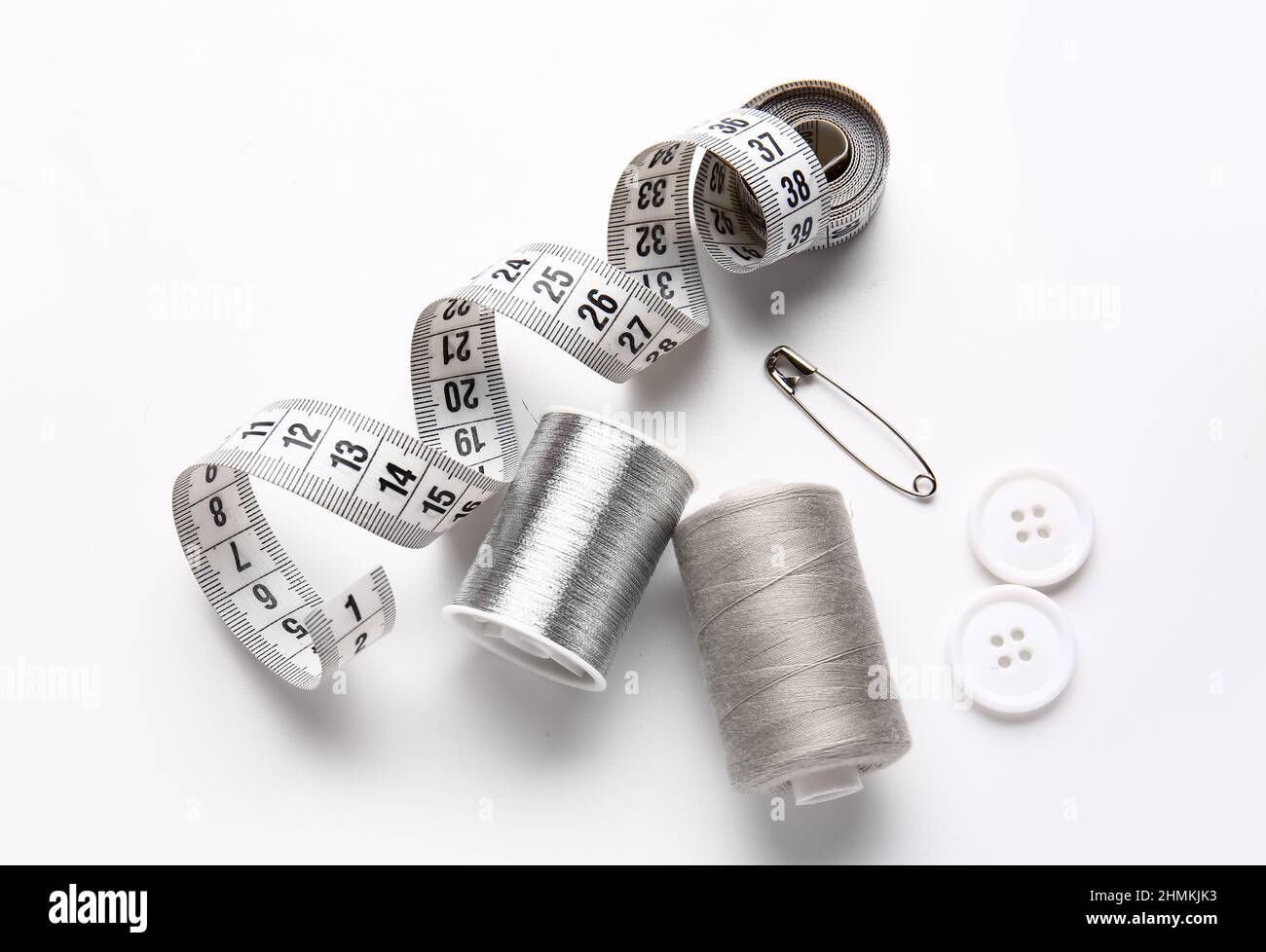 Thread spools with measuring tape and buttons on white background Stock ...