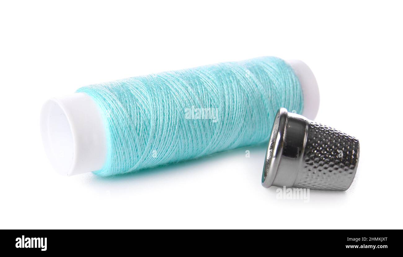 Blue thread spool and thimble on white background Stock Photo - Alamy