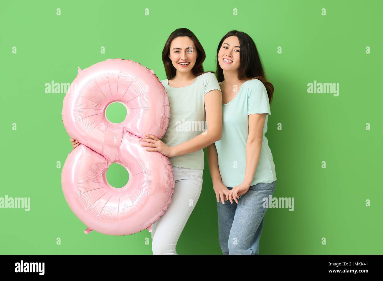 Beautiful women with balloon in shape of figure 8 on green background ...
