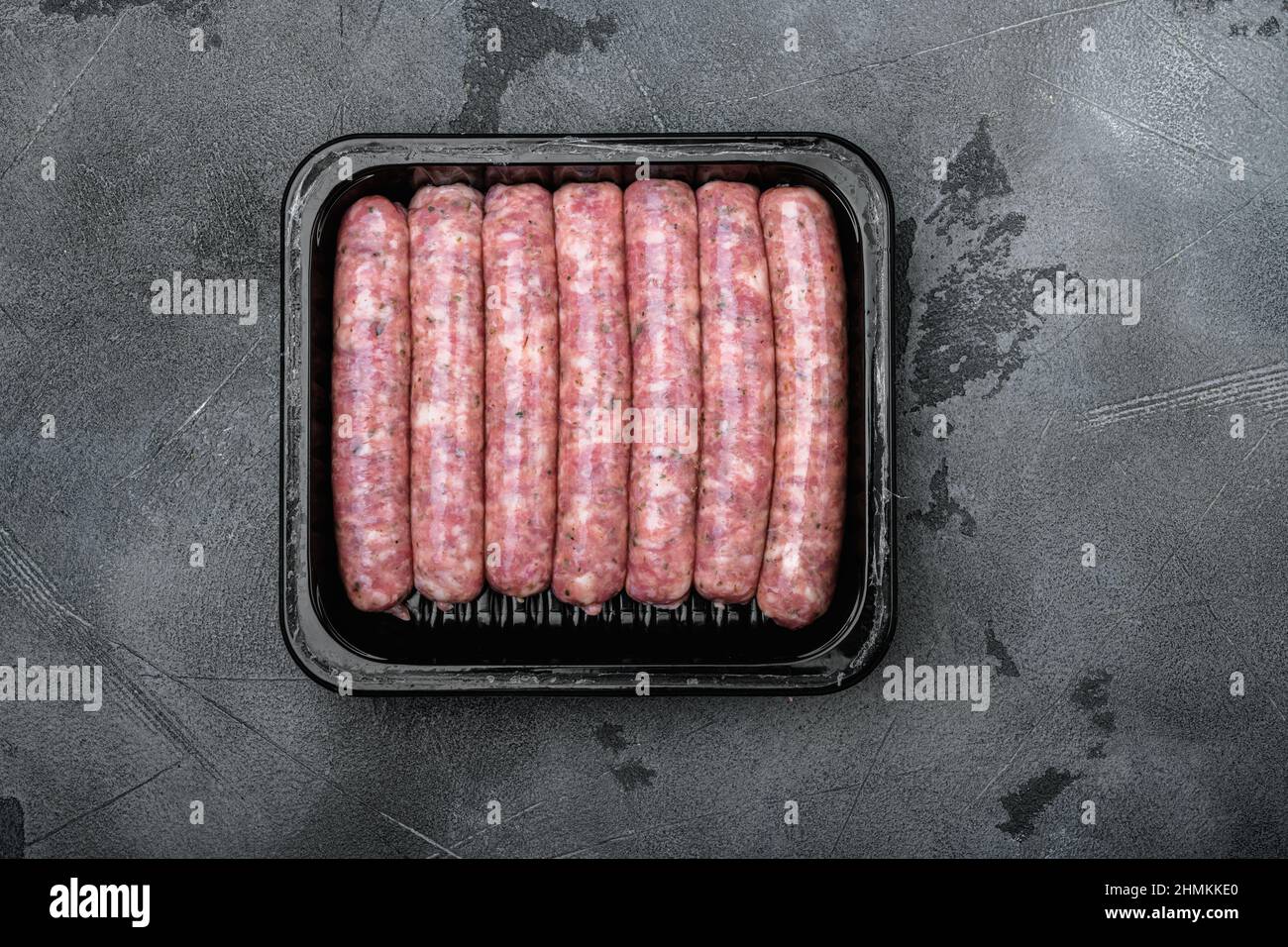 Raw meat sausages in packing box set, on gray stone table background ...