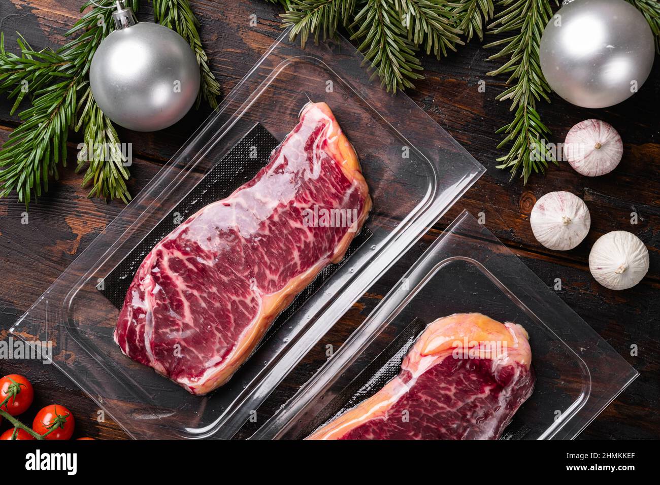 Vacuum packed New-York steak with a Christmas tree set, on old dark ...