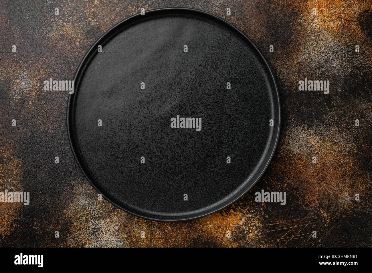 Black plate, on old dark rustic table background Stock Photo - Alamy
