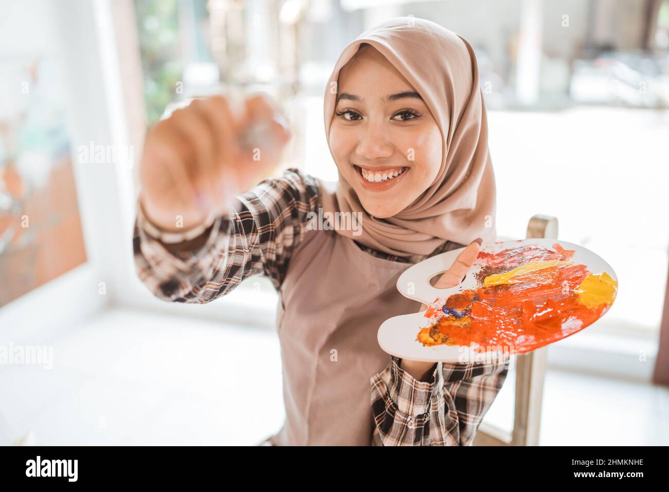 muslim female painter painting on canvas in her workshop Stock Photo ...