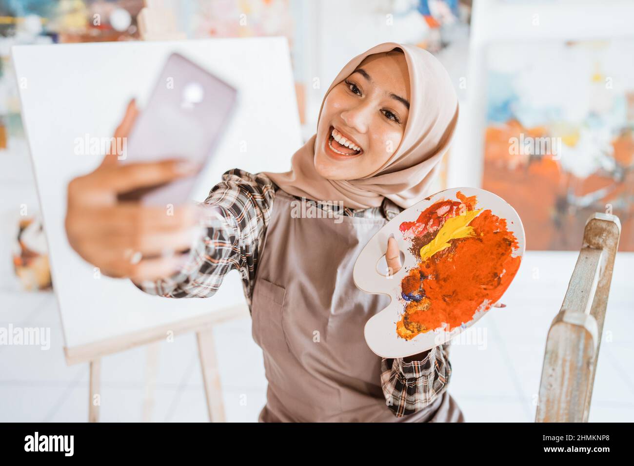 muslim female artist taking selfie picture with her own painting Stock ...