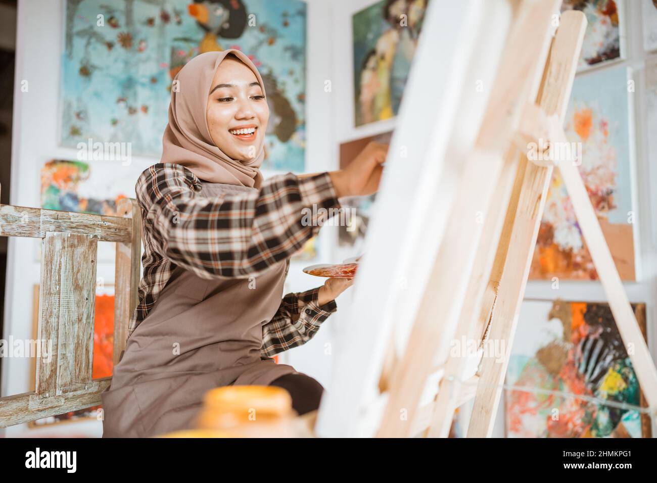 muslim Female artist painting on canvas at home studio Stock Photo - Alamy