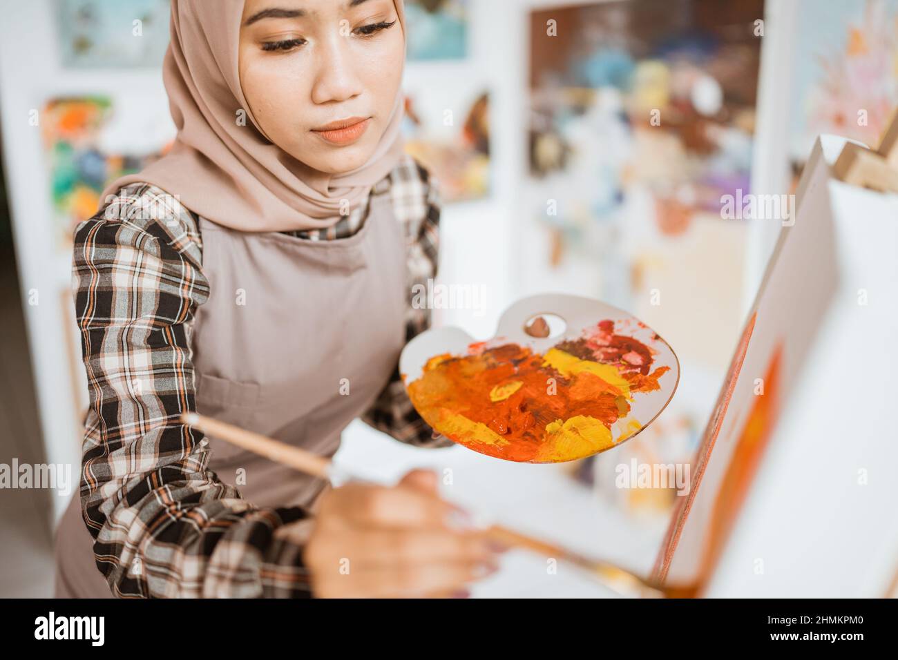 concentrated asian muslim female artist painting on canvas Stock Photo ...