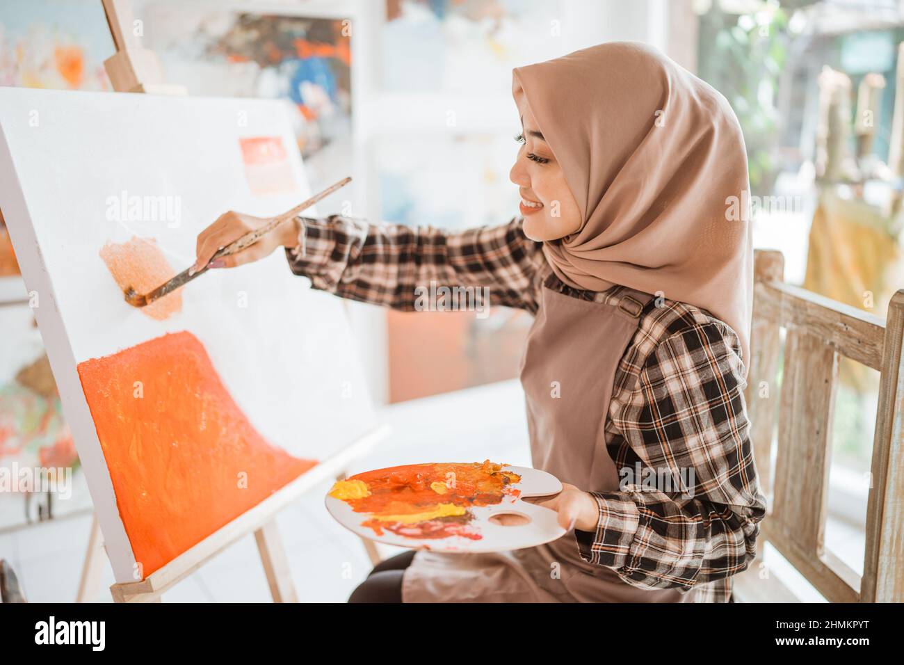 muslim Female artist painting on canvas at home studio Stock Photo - Alamy