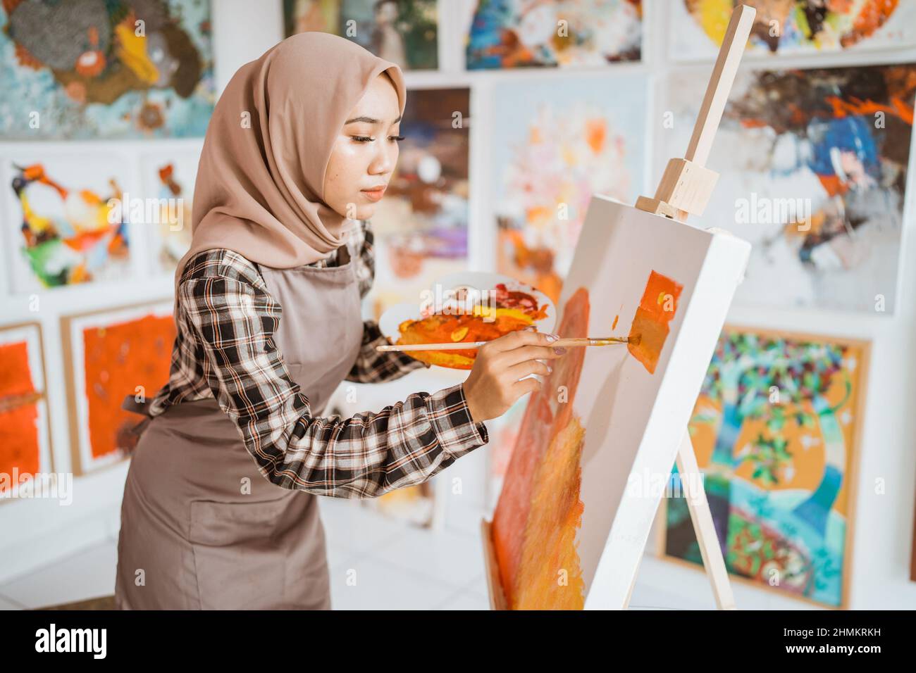 concentrated asian muslim female artist painting on canvas Stock Photo ...