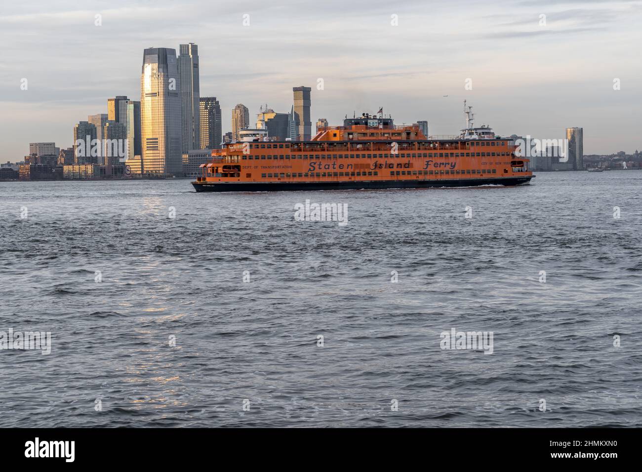 Yellow staten island ferry crosses the Hudson river in NYC with Neward ...