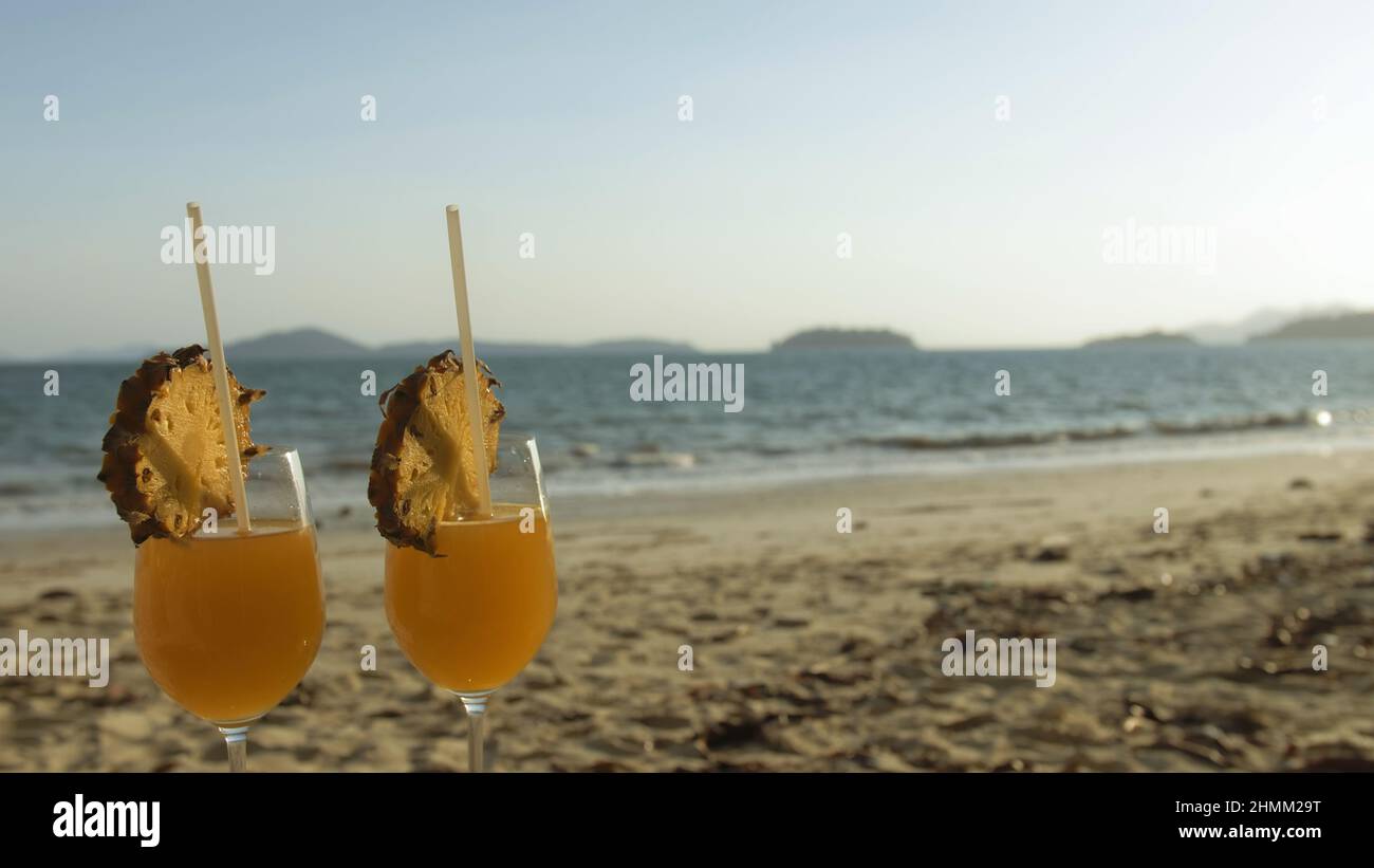 Cocktail Pina Colada, in slice pineapple, at sunset. Blur background ...