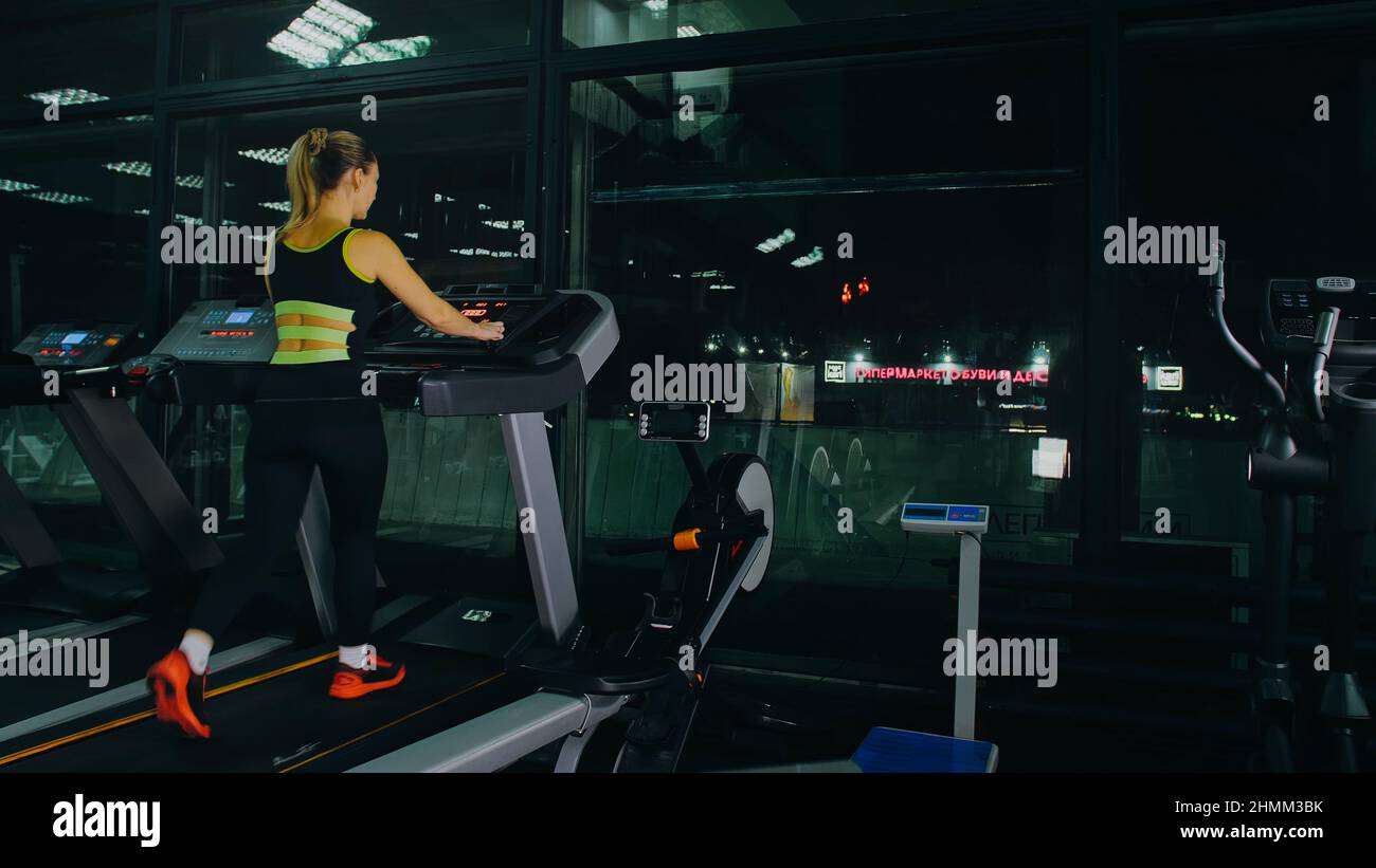 Fit Athletic Woman Running on the Treadmill, Doing Her Fitness Exercise ...